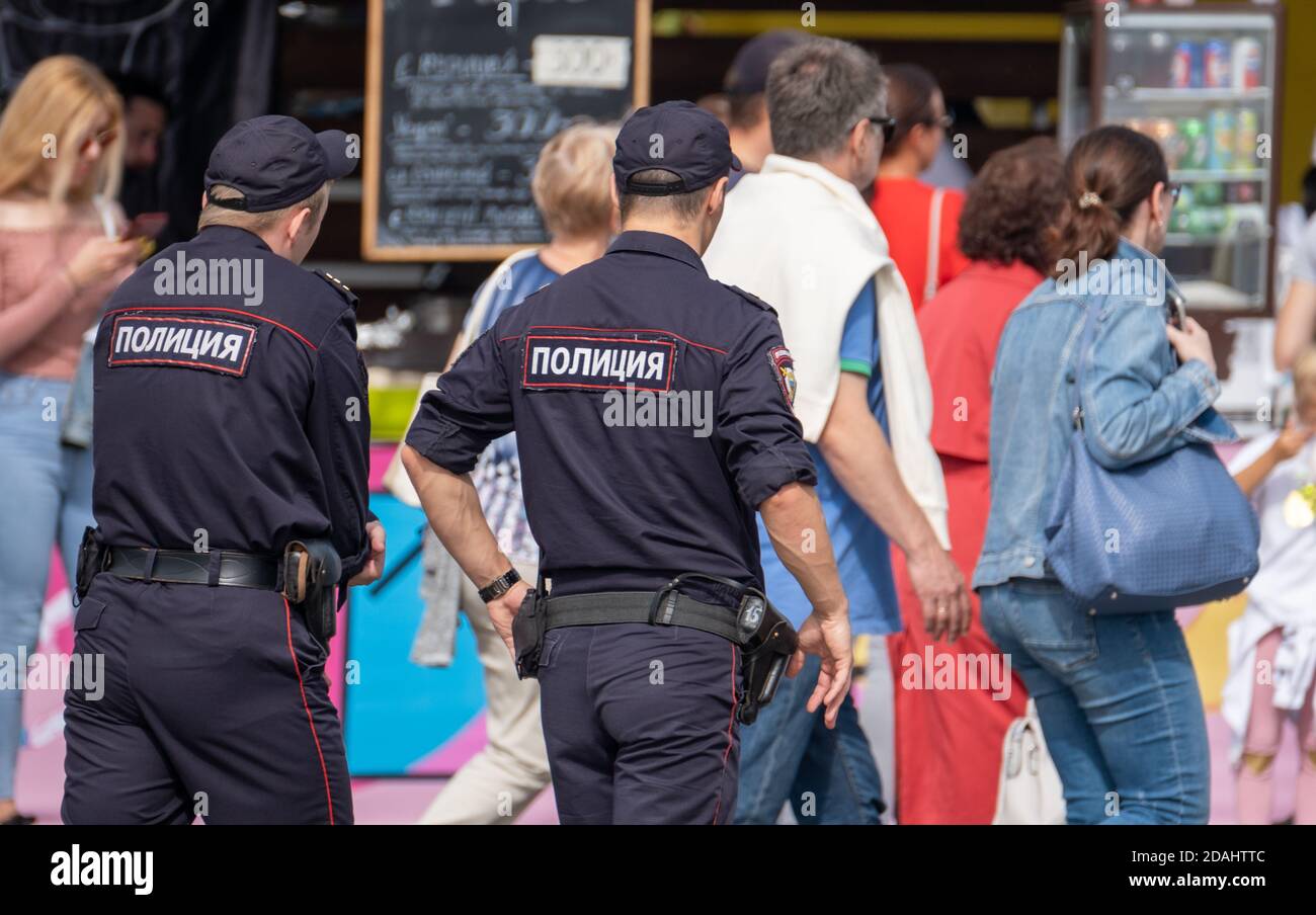Police officers patrolling square during fair Stock Photo - Alamy