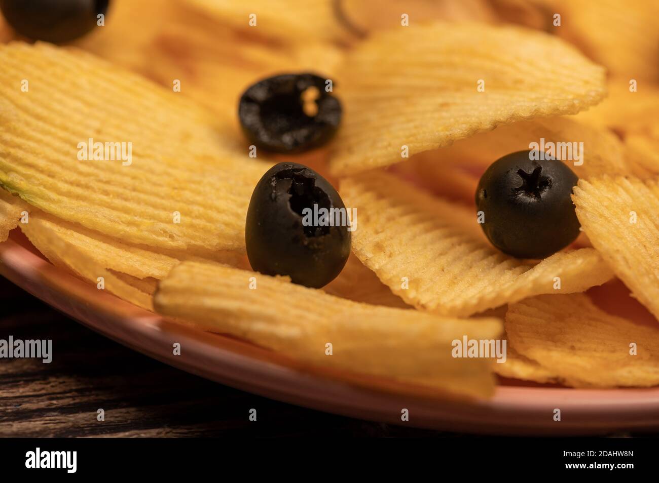 Crispy, delicious potato chips with olives. Close up Stock Photo - Alamy