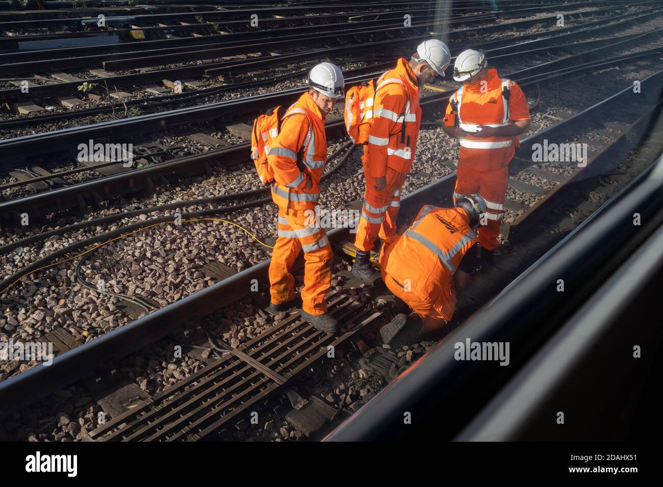 Seen from a passing train carriage window, an engineering work gang ...