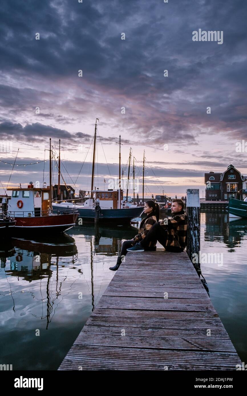 Urk Flevoland Holland,couple men and woman watching sunset at the small ...