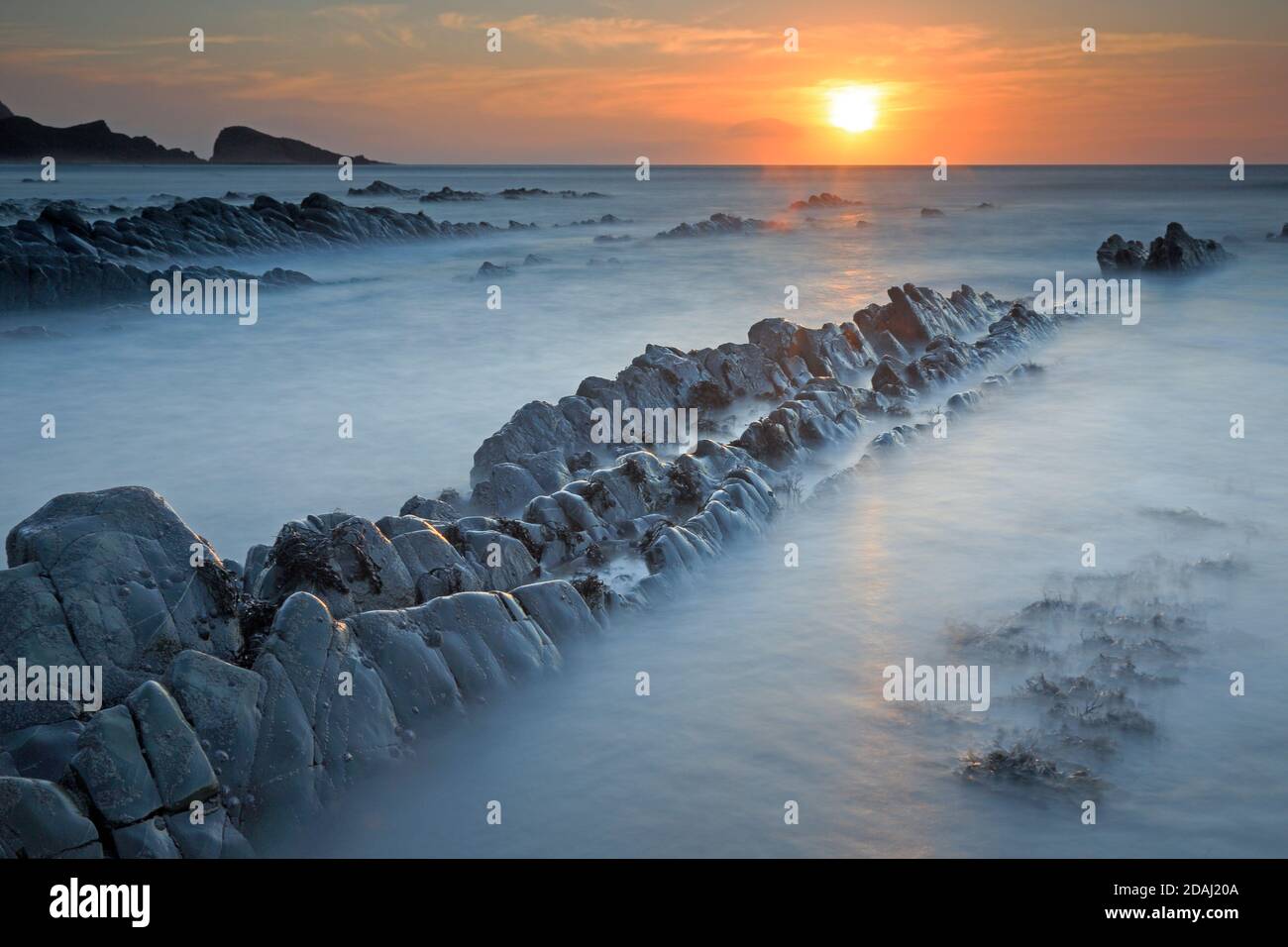 View of the rock ledges at sunset at Welcombe Mouth Beach on the Devon ...