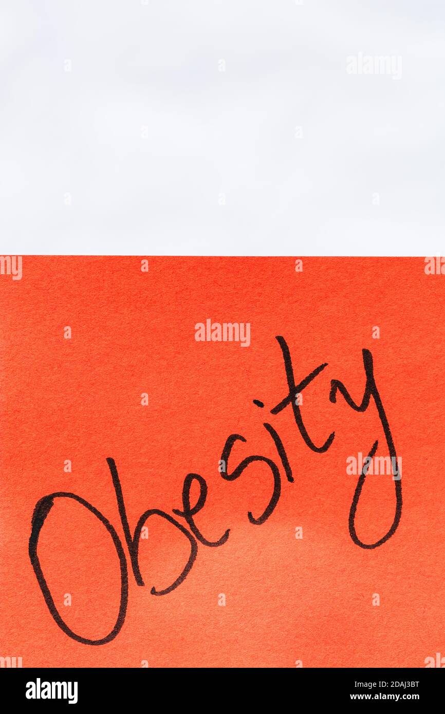 Obesity handwriting text close up isolated on orange paper with copy ...