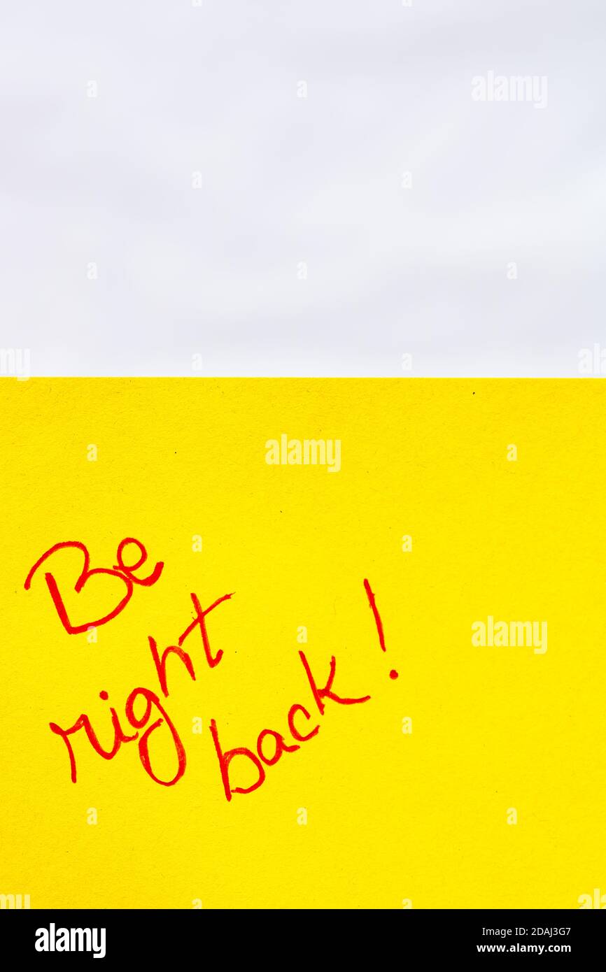Be right back handwriting text close up isolated on orange paper with ...