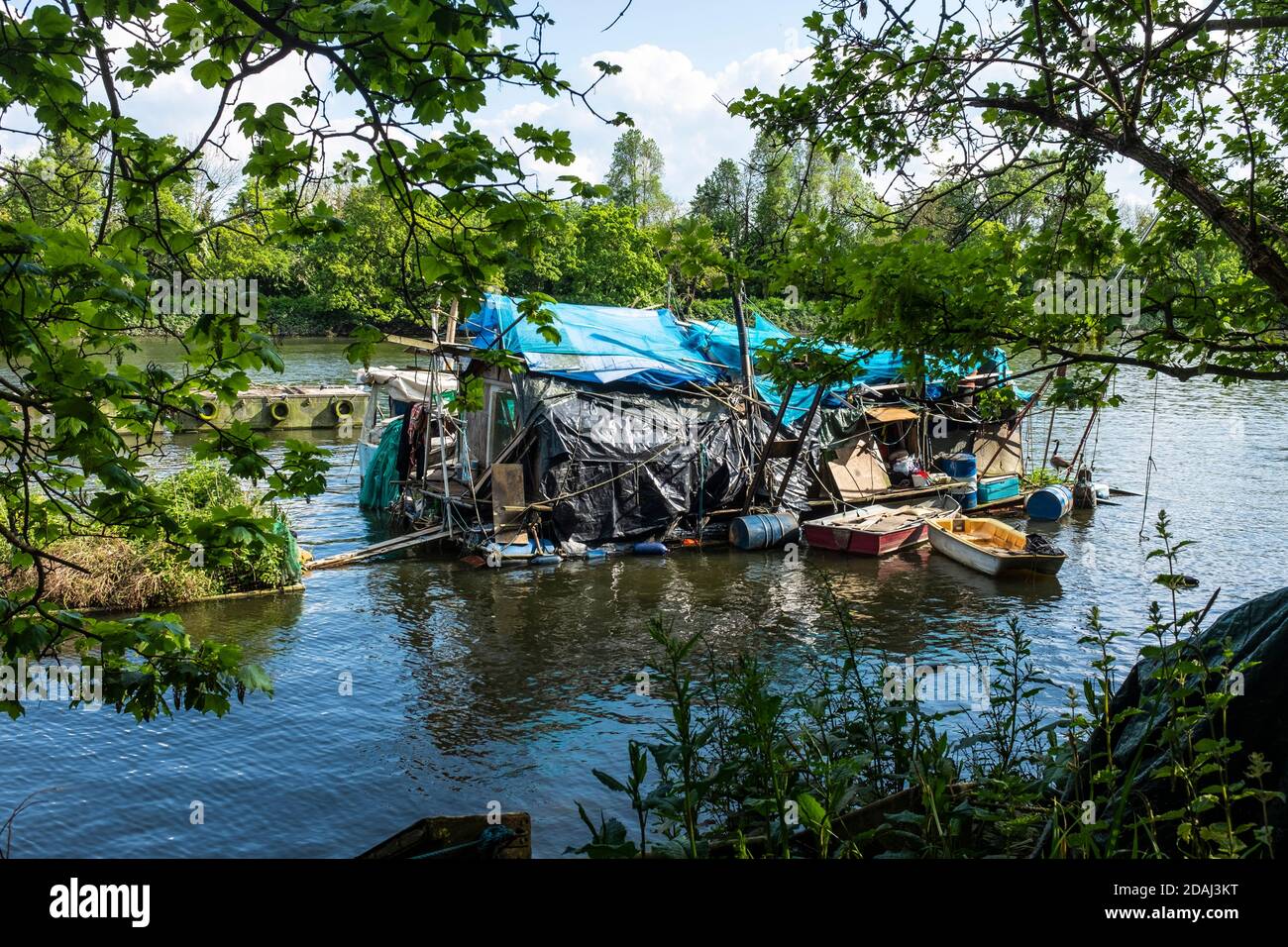 A unique looking DIY floating houseboat with much plastic sheeting and ...