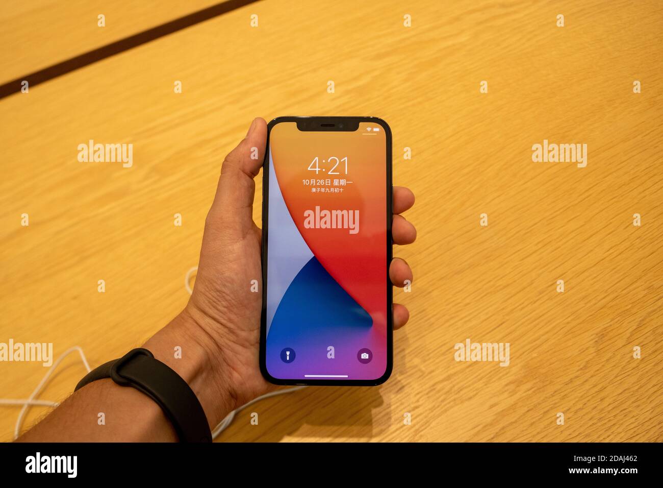 A hand of a person holds an Apple iPhone 12 Pro at an Apple store in ...