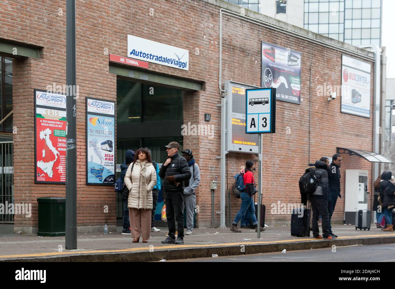 People are waiting for the bus at the city bus station stop. Milan of ...