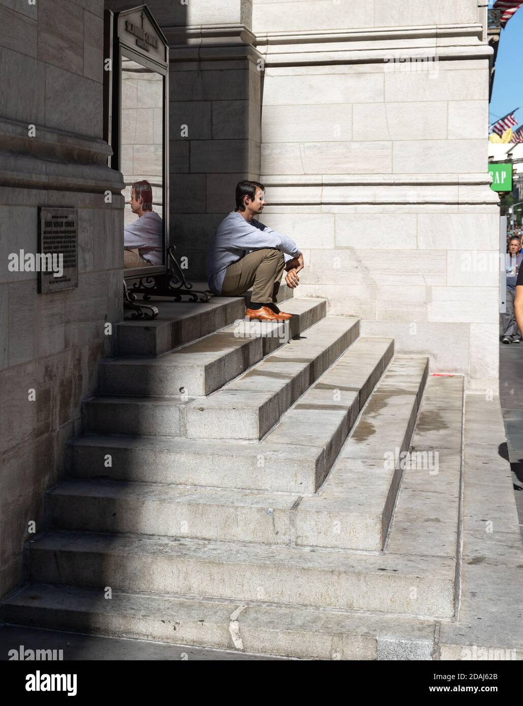 NEW YORK, USA - Sep 23, 2017: Manhattan street scene. Man is sitting on ...