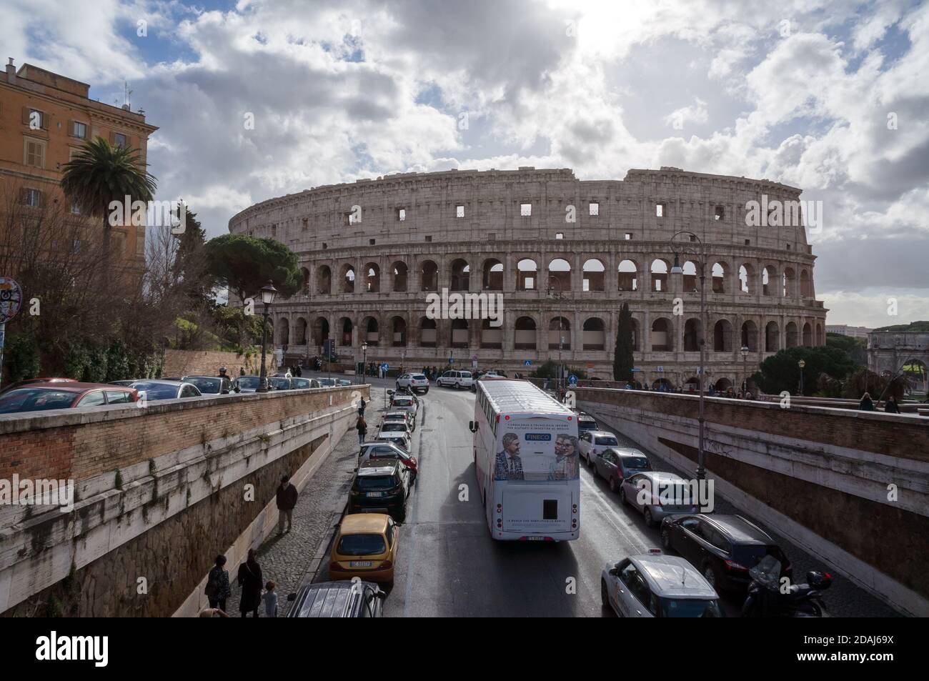 City road with transport in front of the amphitheater Colosseum ...
