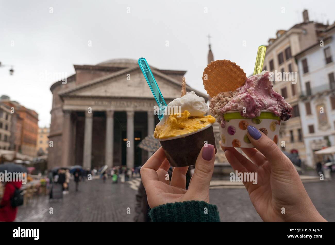 Two glasses of Italian ice cream in the hands of a girl against the ...
