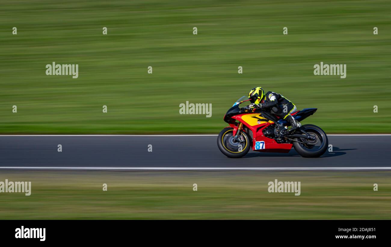 A panning shot of a racing bike cornering on a track Stock Photo - Alamy
