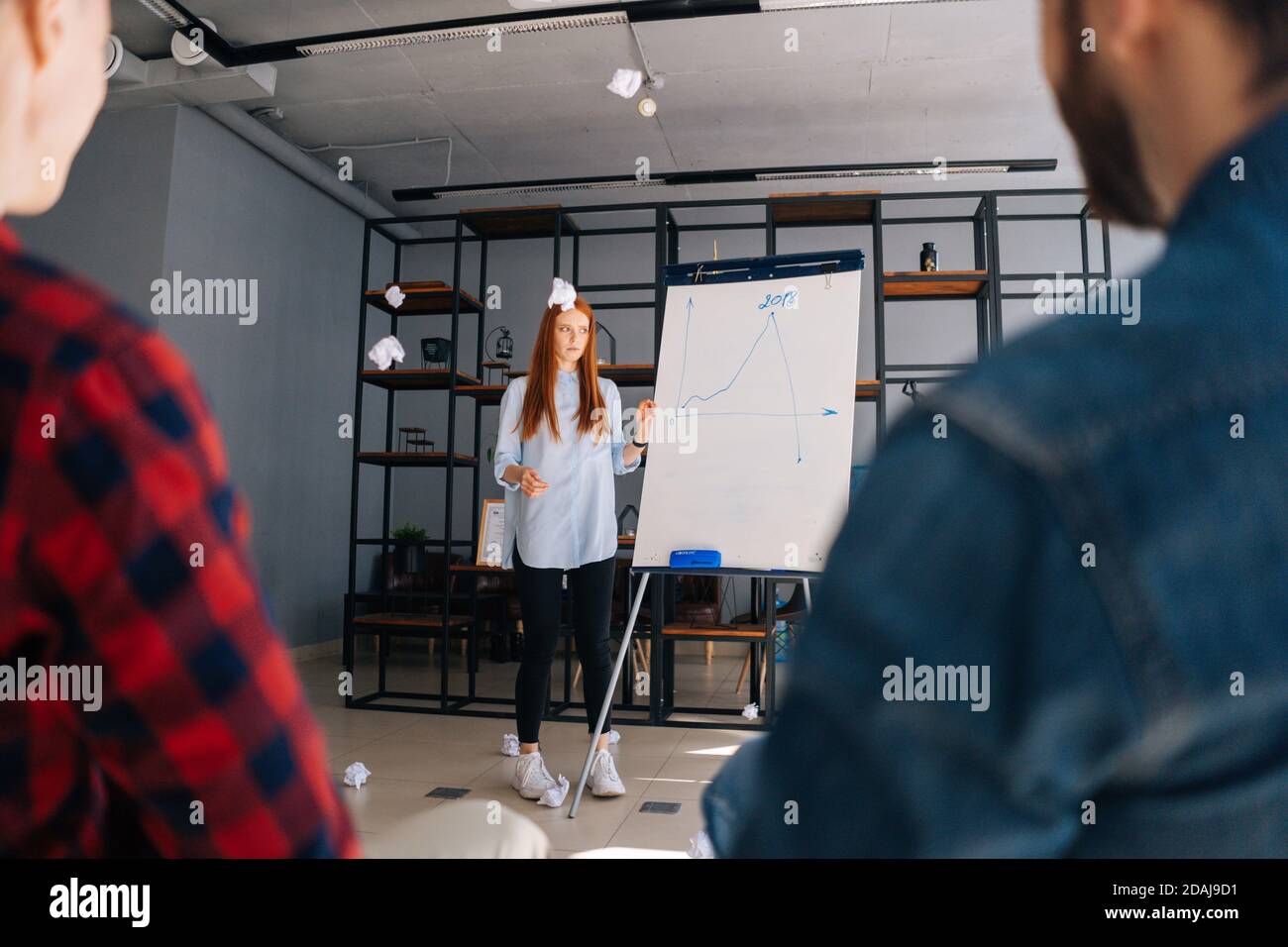 Dissatisfied colleagues throw crumpled paper balls at frightened woman ...