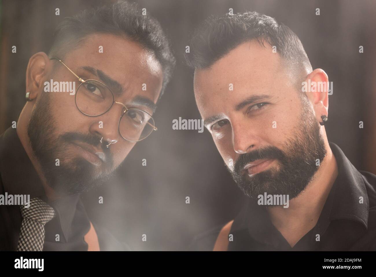 two men, one caucasian and the other african american, look defiant on ...