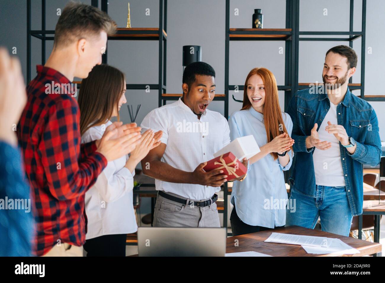Happy team of multi-ethnic businesspeople congratulate African-American ...