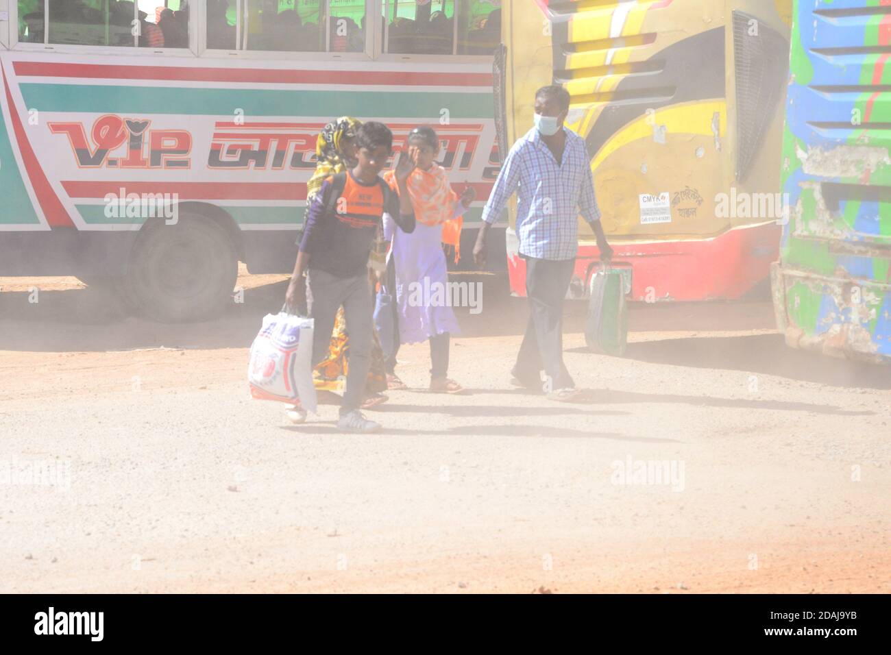 Peoples walk through a dusty busy road in Dhaka, Bangladesh, on ...