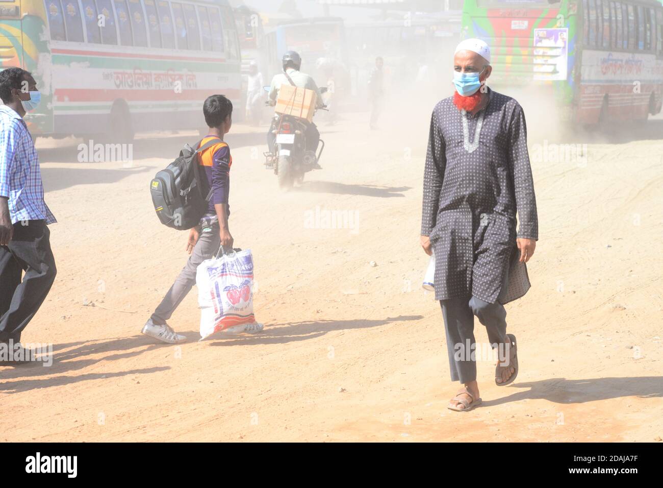 Peoples walk through a dusty busy road in Dhaka, Bangladesh, on ...