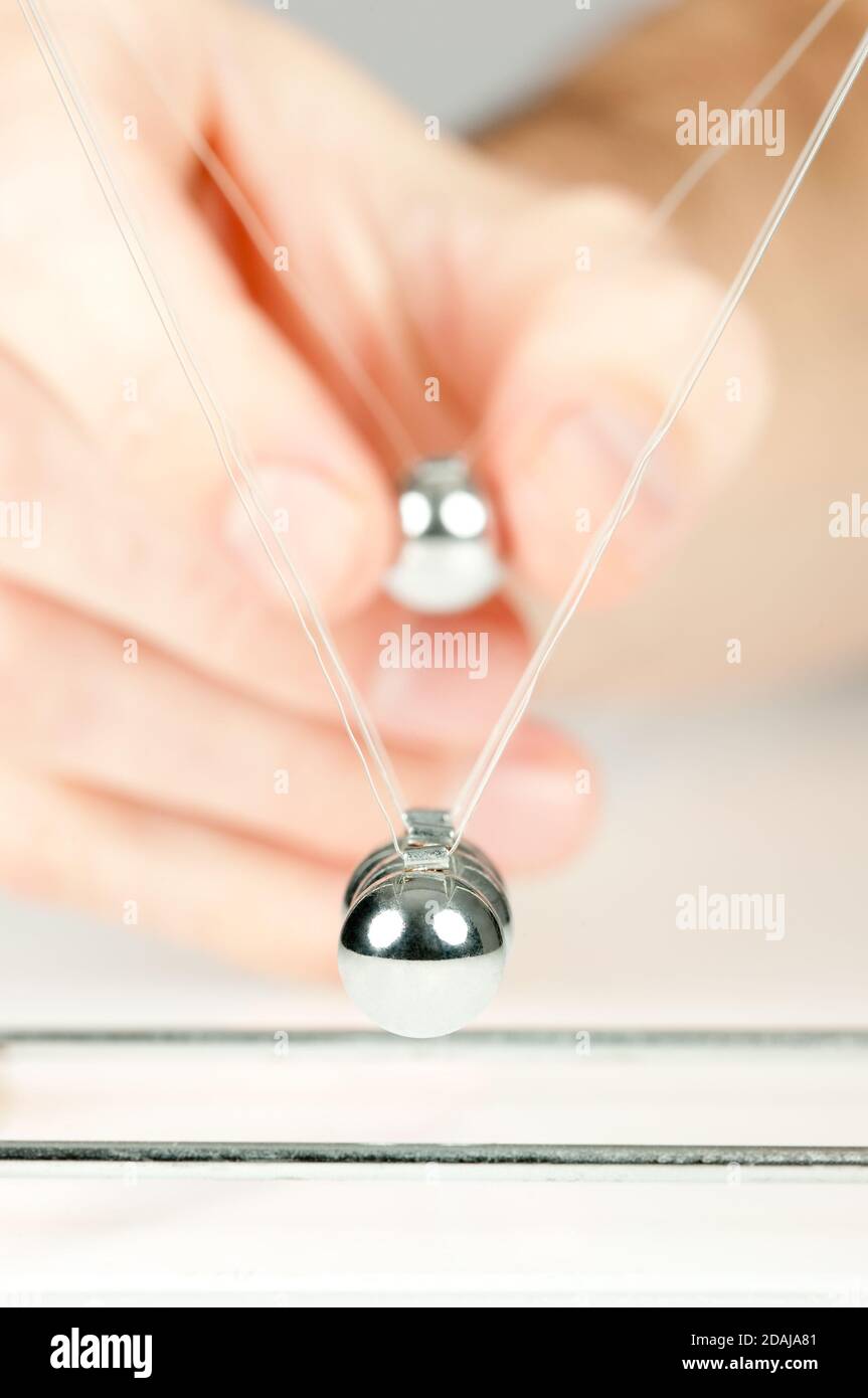 Hand holding pendulum ball hi-res stock photography and images - Alamy