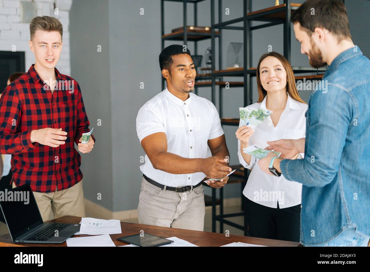 African American man manager giving salary in cash to happy employees ...