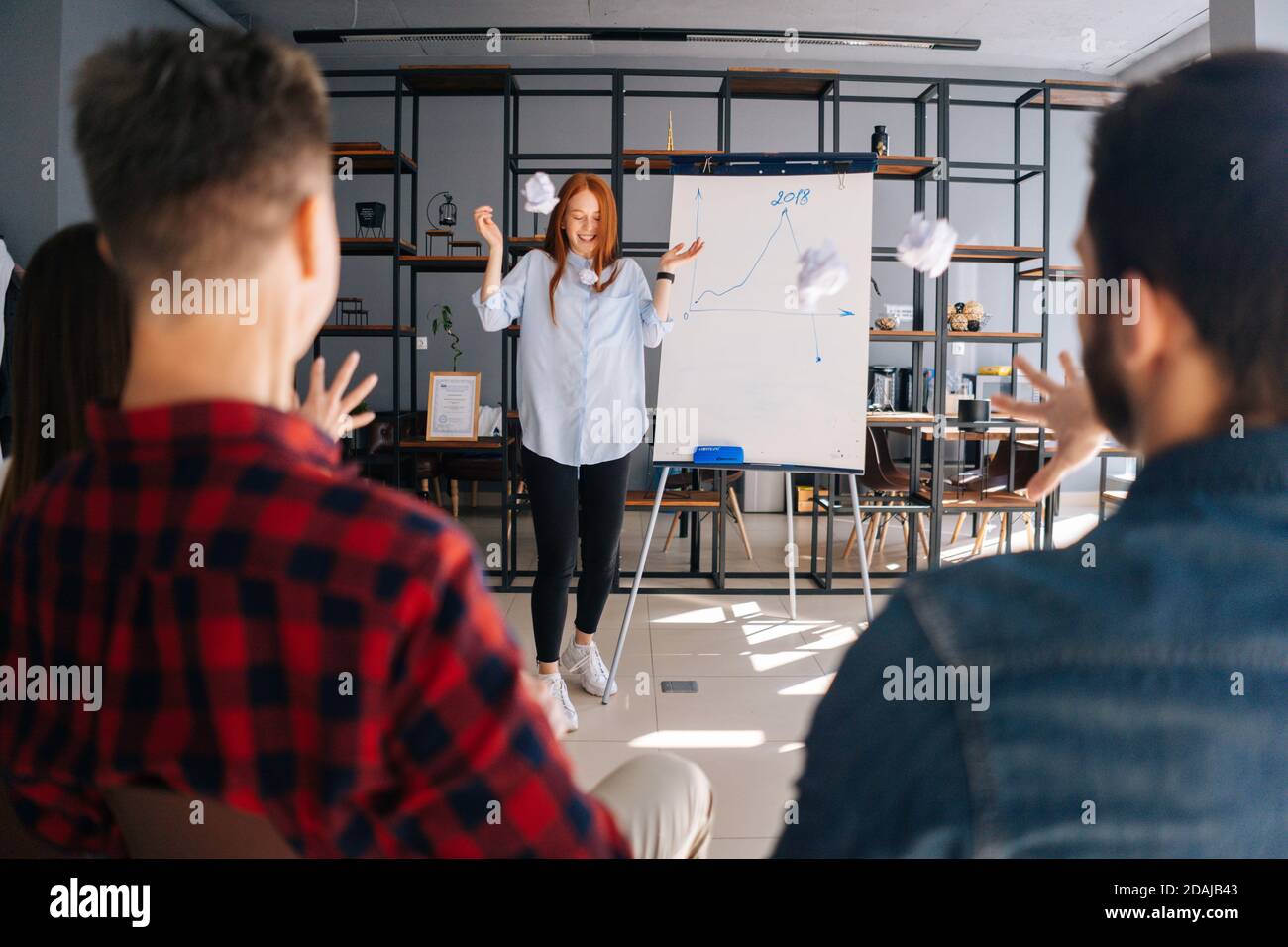 Dissatisfied colleagues throw crumpled paper balls at frightened woman ...