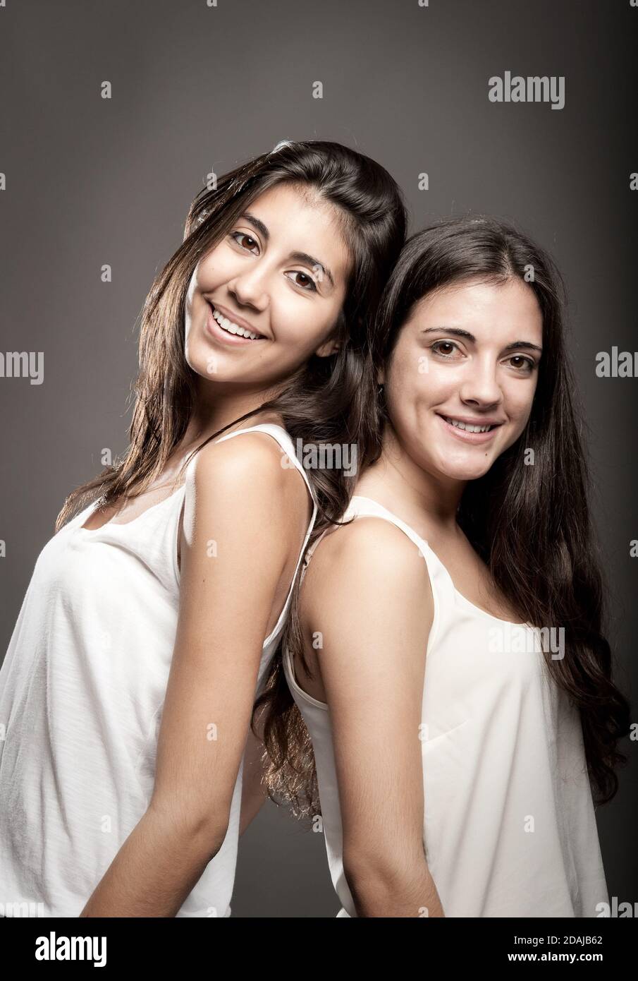 portrait of two sisters back to back Stock Photo - Alamy