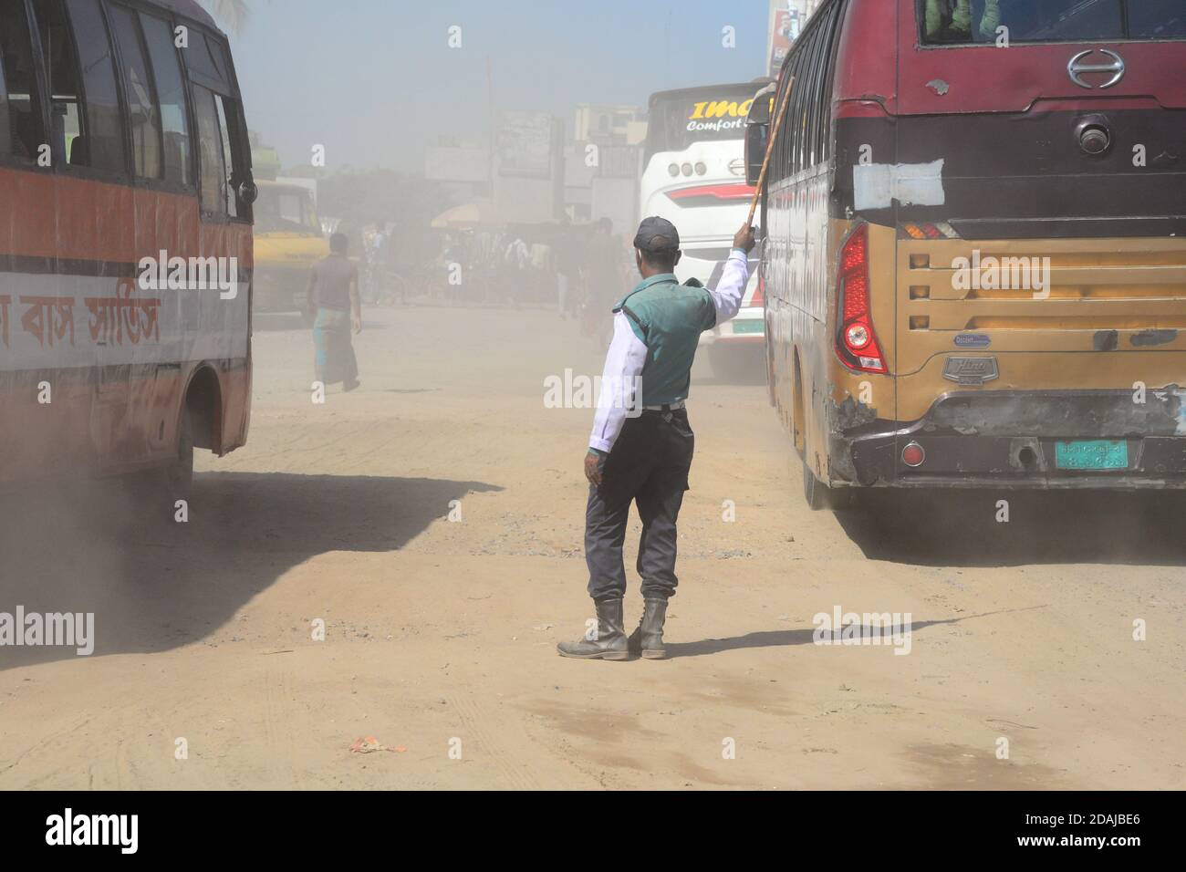 Peoples walk through a dusty busy road in Dhaka, Bangladesh, on ...