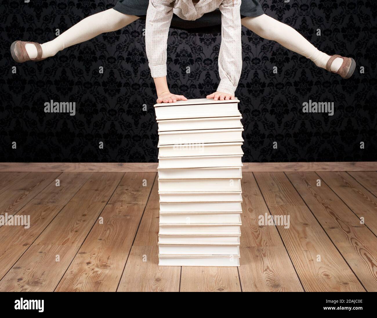 girl jumping through a stack of books on a vintage background Stock ...