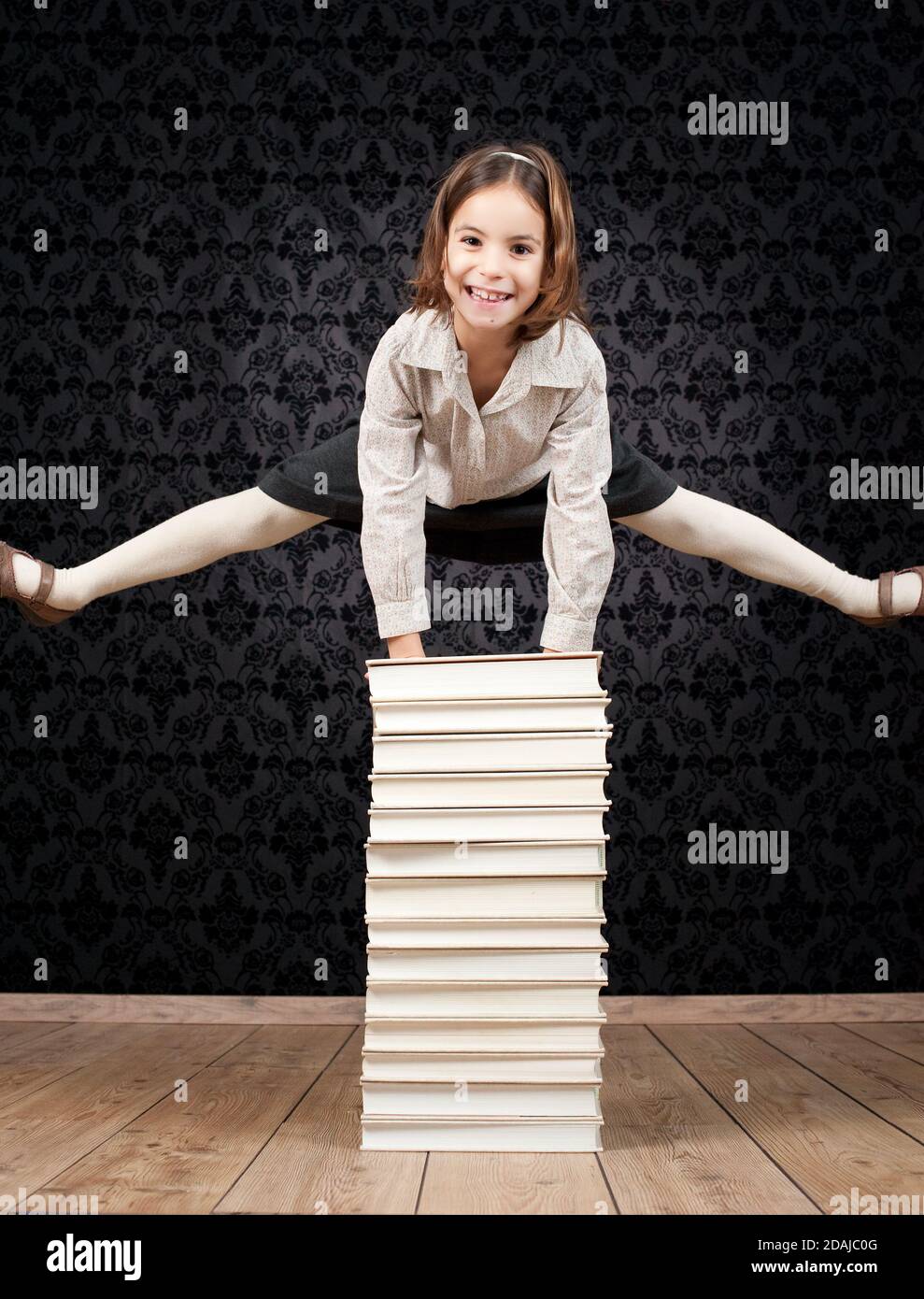 girl jumping through a stack of books on a vintage background Stock ...