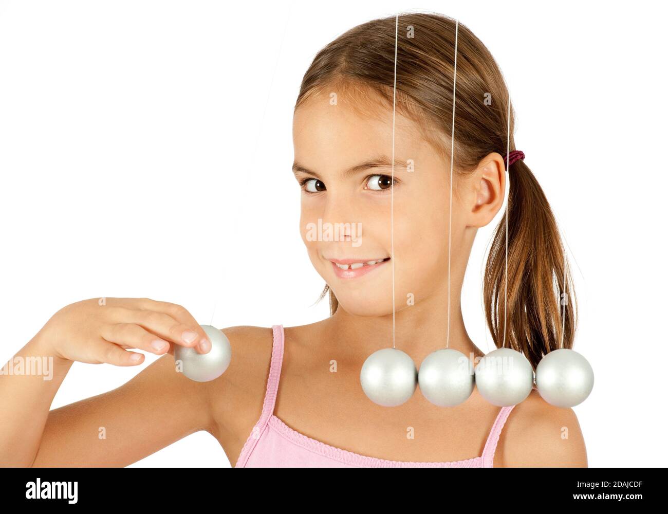 young girl holding a pendulum ball isolated on white background Stock ...