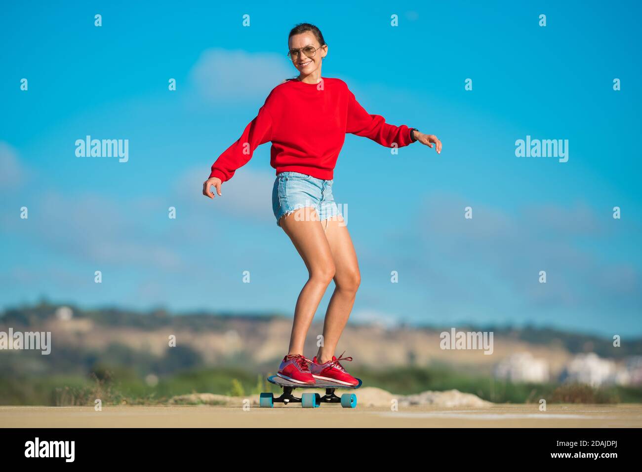 Young woman riding longboard on a sunny summer day Stock Photo - Alamy