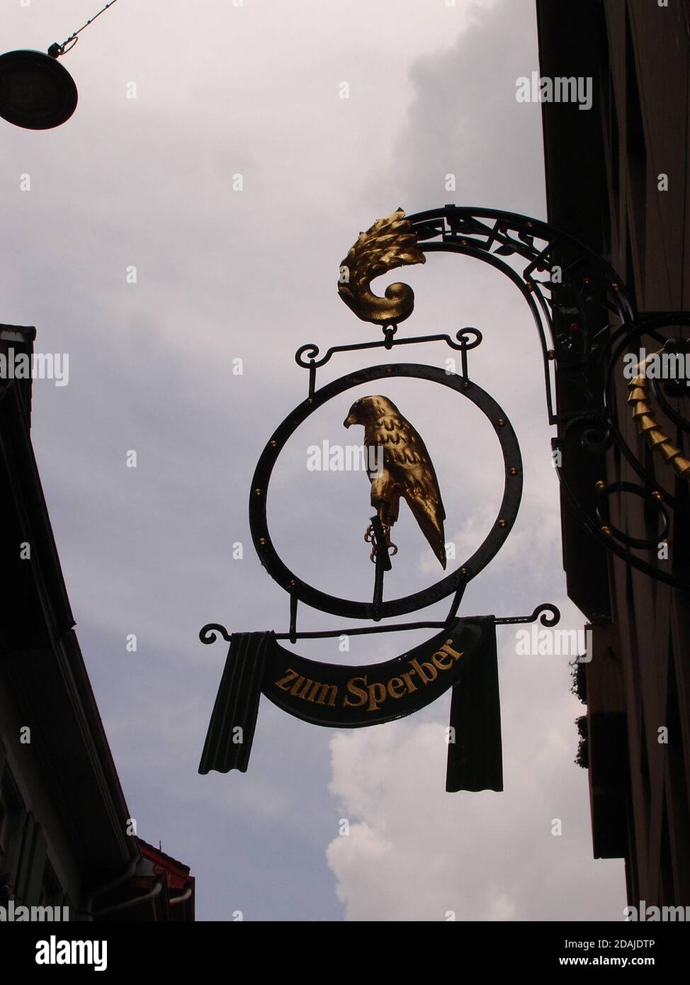 Golden sparrow-hawk wrought iron sign proudle swings outside a ...