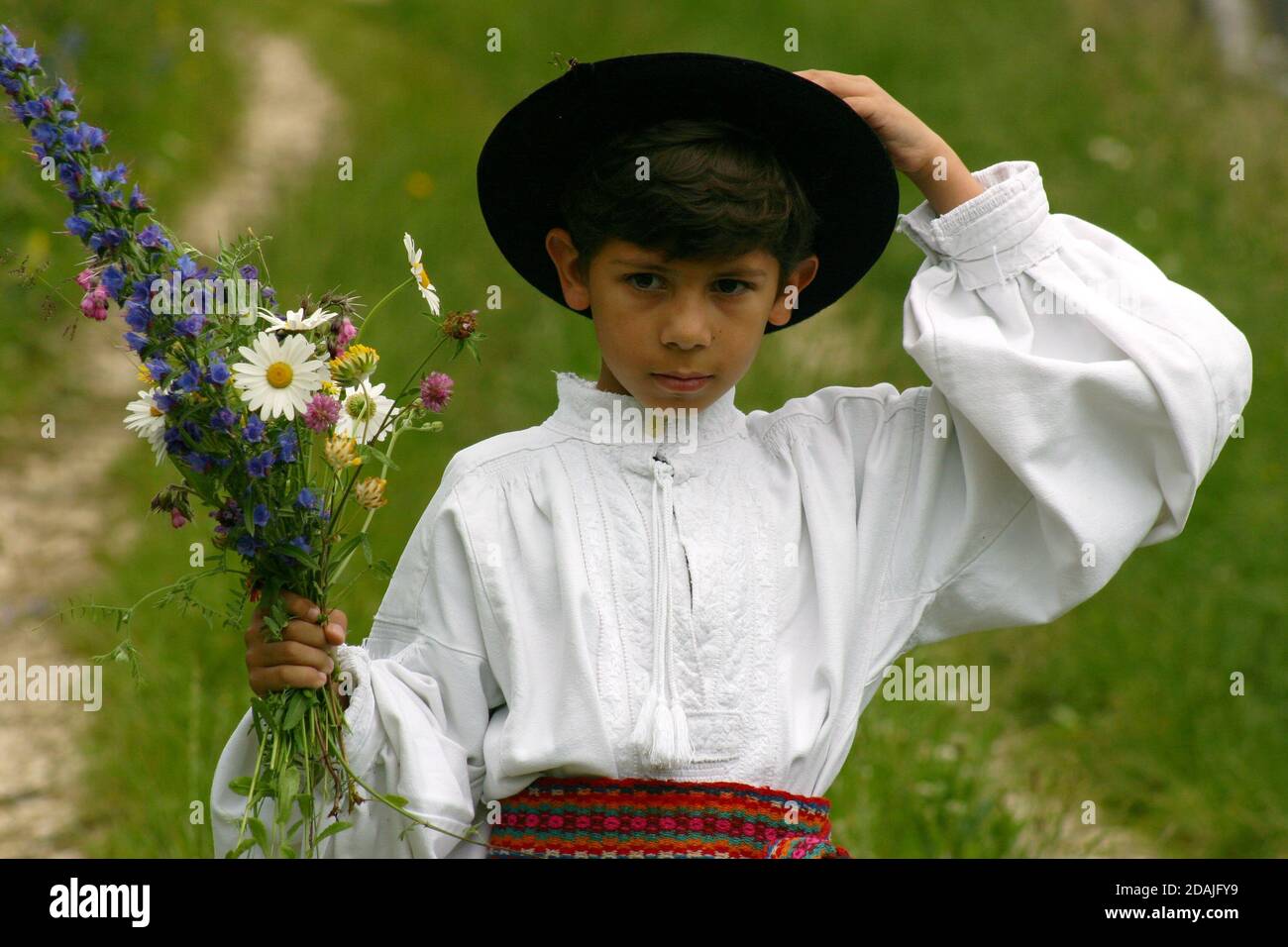 Transylvania, Romania. Young boy in traditional garments with bouquet ...
