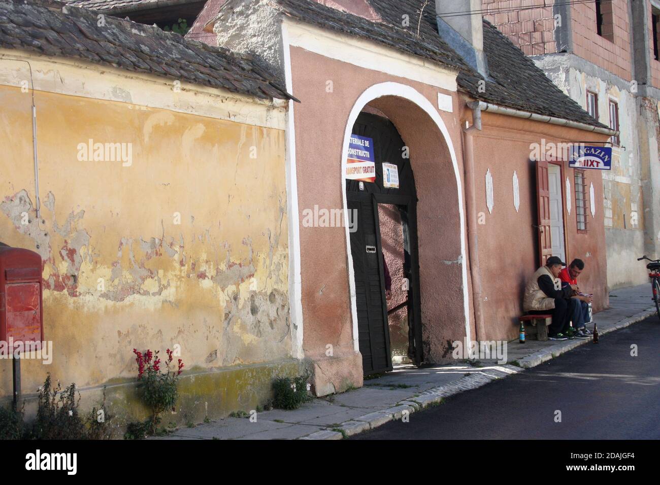 Old adjoined Saxon houses in Sibiu County, Romania. Local men drinking ...