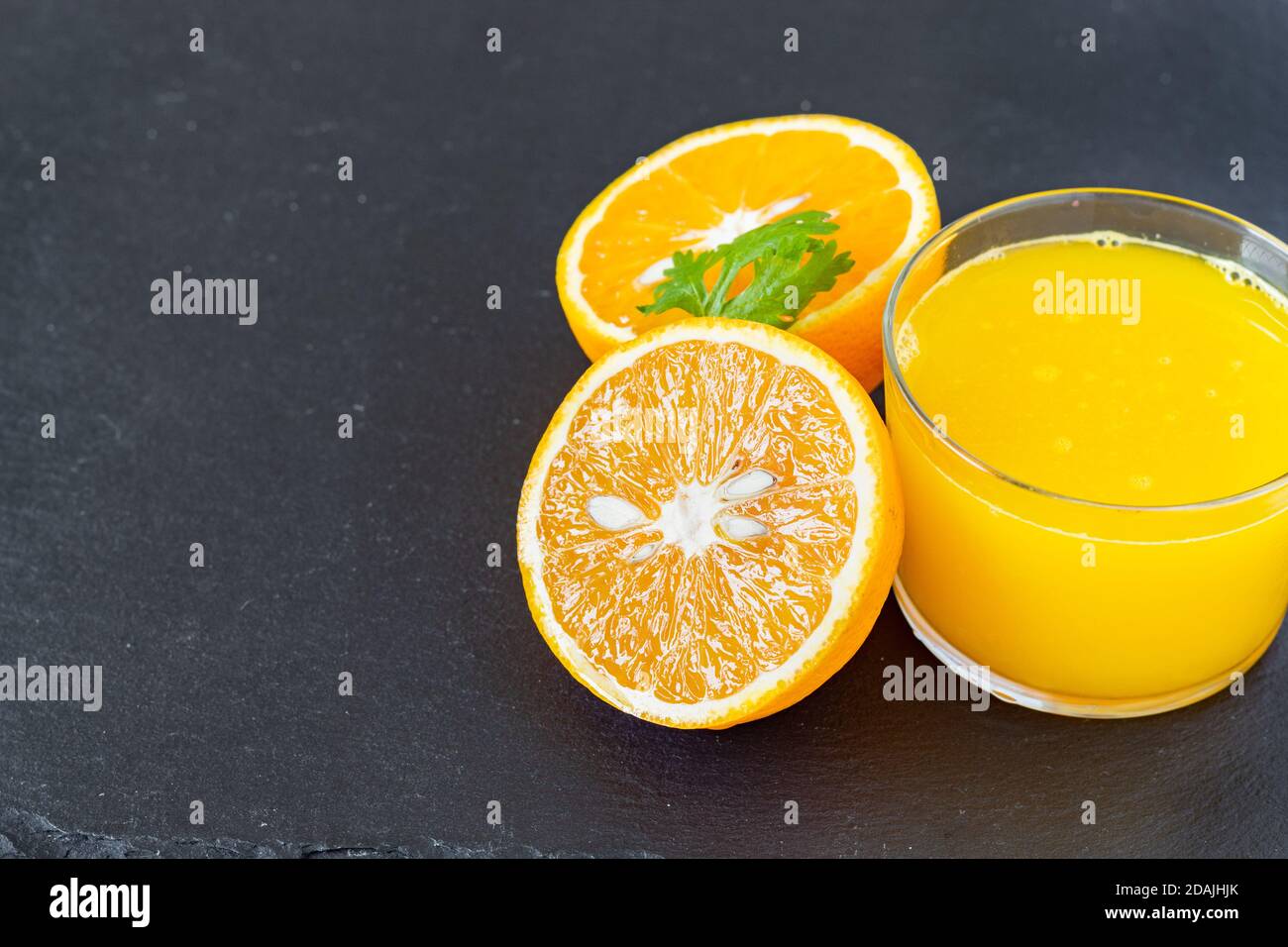 Glass of orange and orange juice cut in half Stock Photo - Alamy