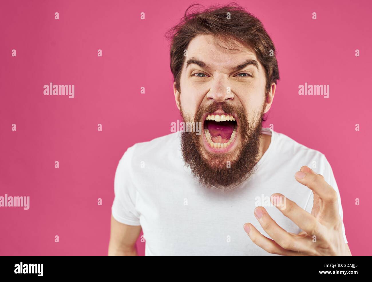 angry man with beard holds hands near face and stress irritability ...