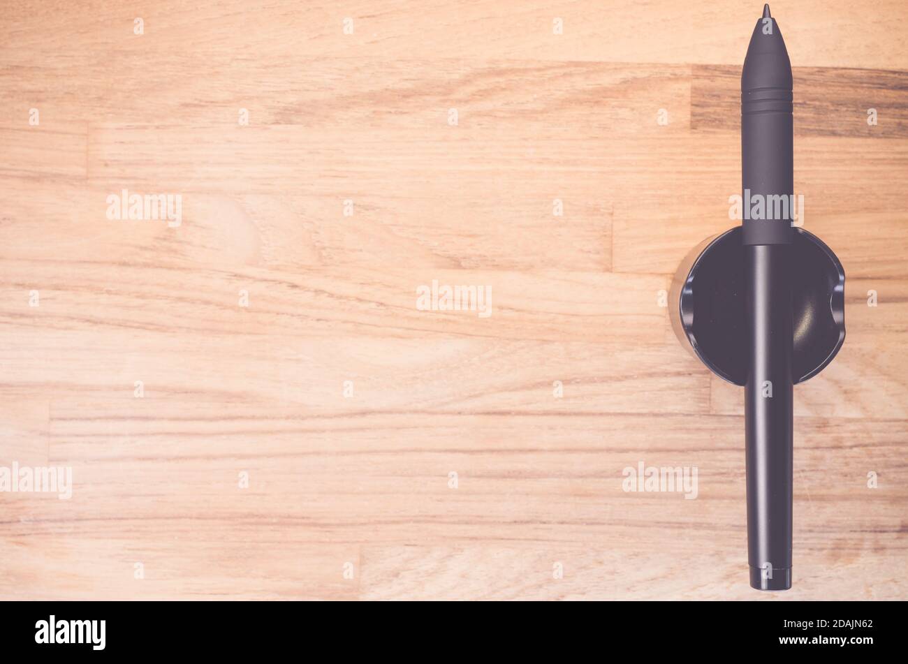 Digital drawing pen and pen holder on a wooden surface with copy space ...