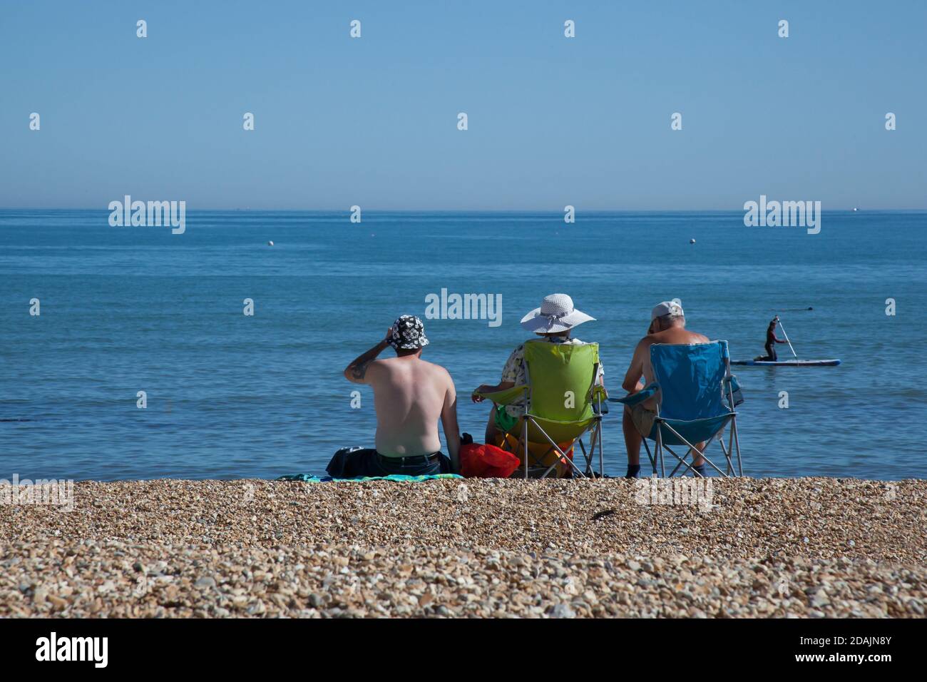 A family sat on the beach at Overcombe, Dorset in the UK, taken on the ...