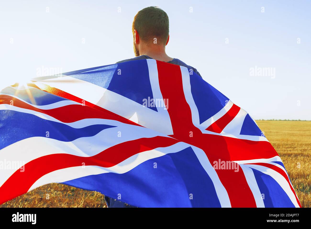 Man with a flag of Great Britain standing in field Stock Photo - Alamy