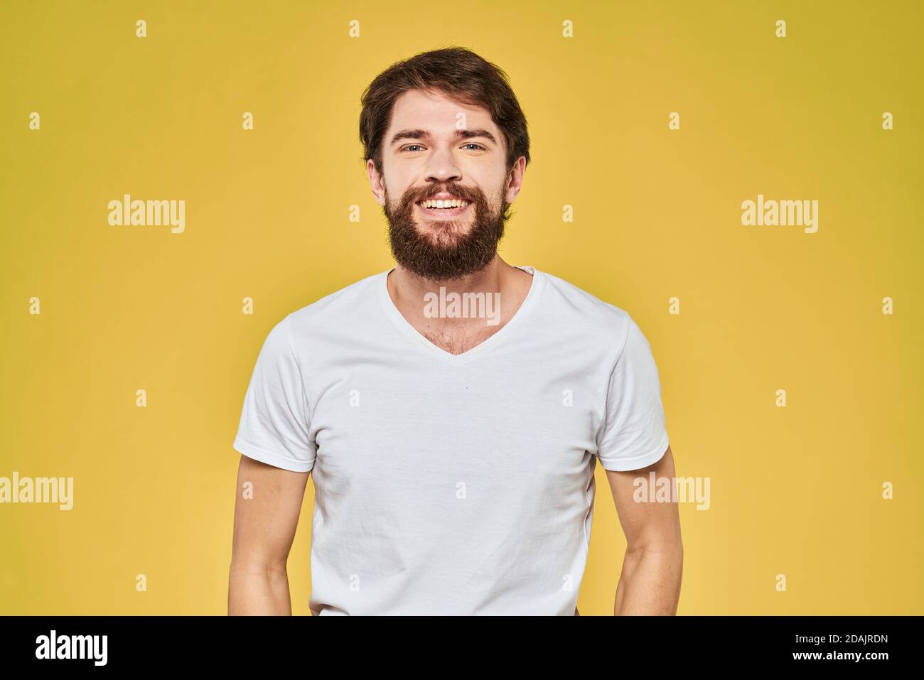 Man gesturing with hands emotions lifestyle white t-shirt yellow isolated background Stock Photo ...