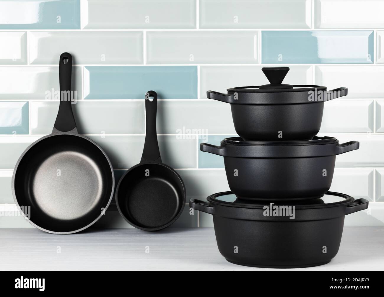 Set of black cookware on kitchen counter Stock Photo - Alamy