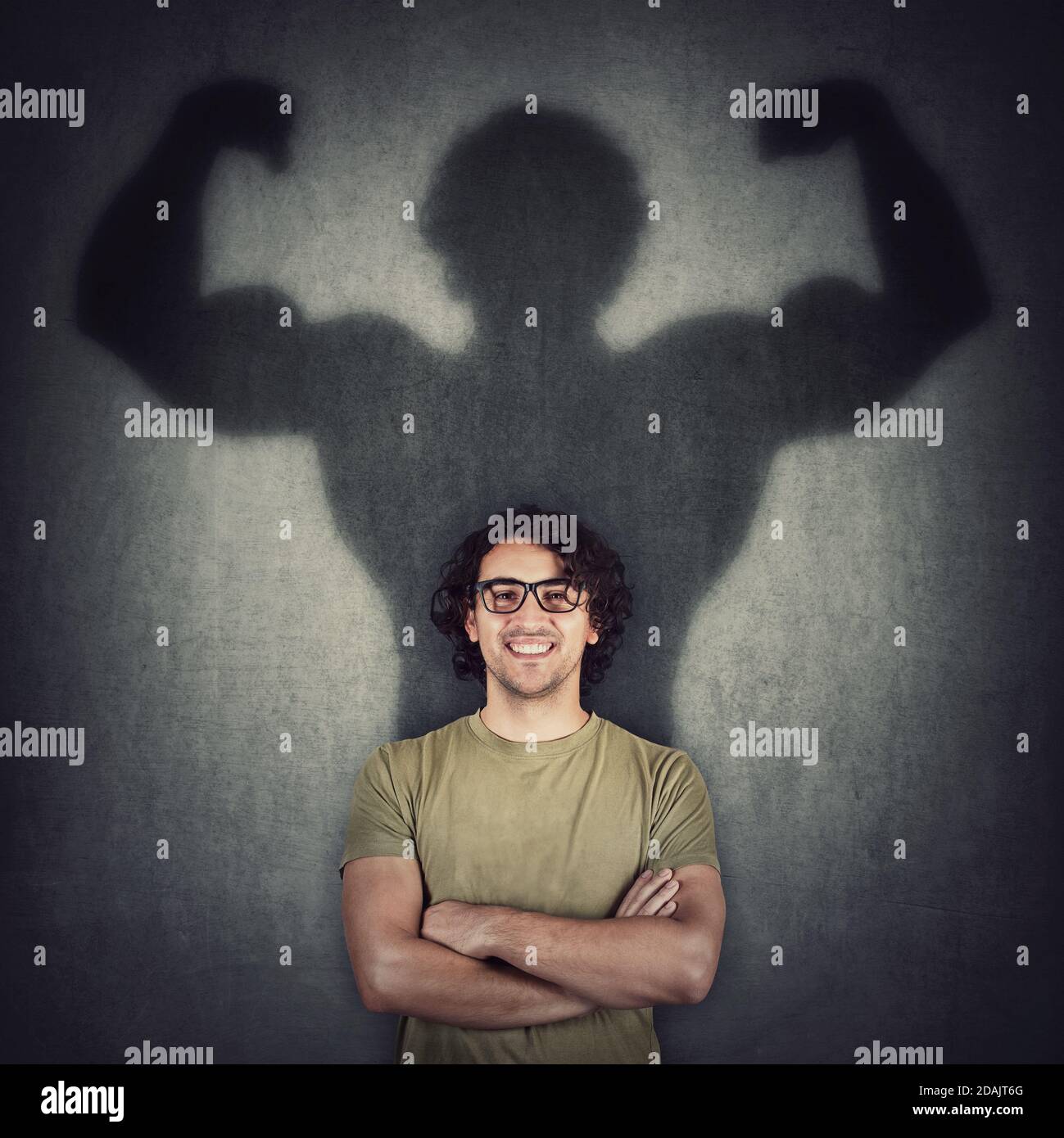Confident young man shadows transforms into a muscular person on the ...