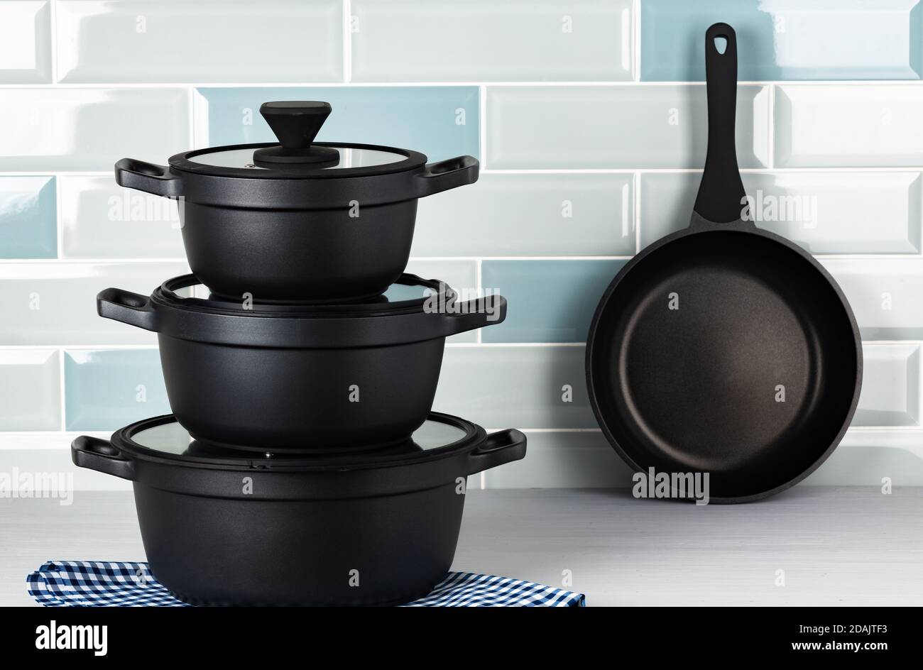 Set of black cookware on kitchen counter Stock Photo - Alamy