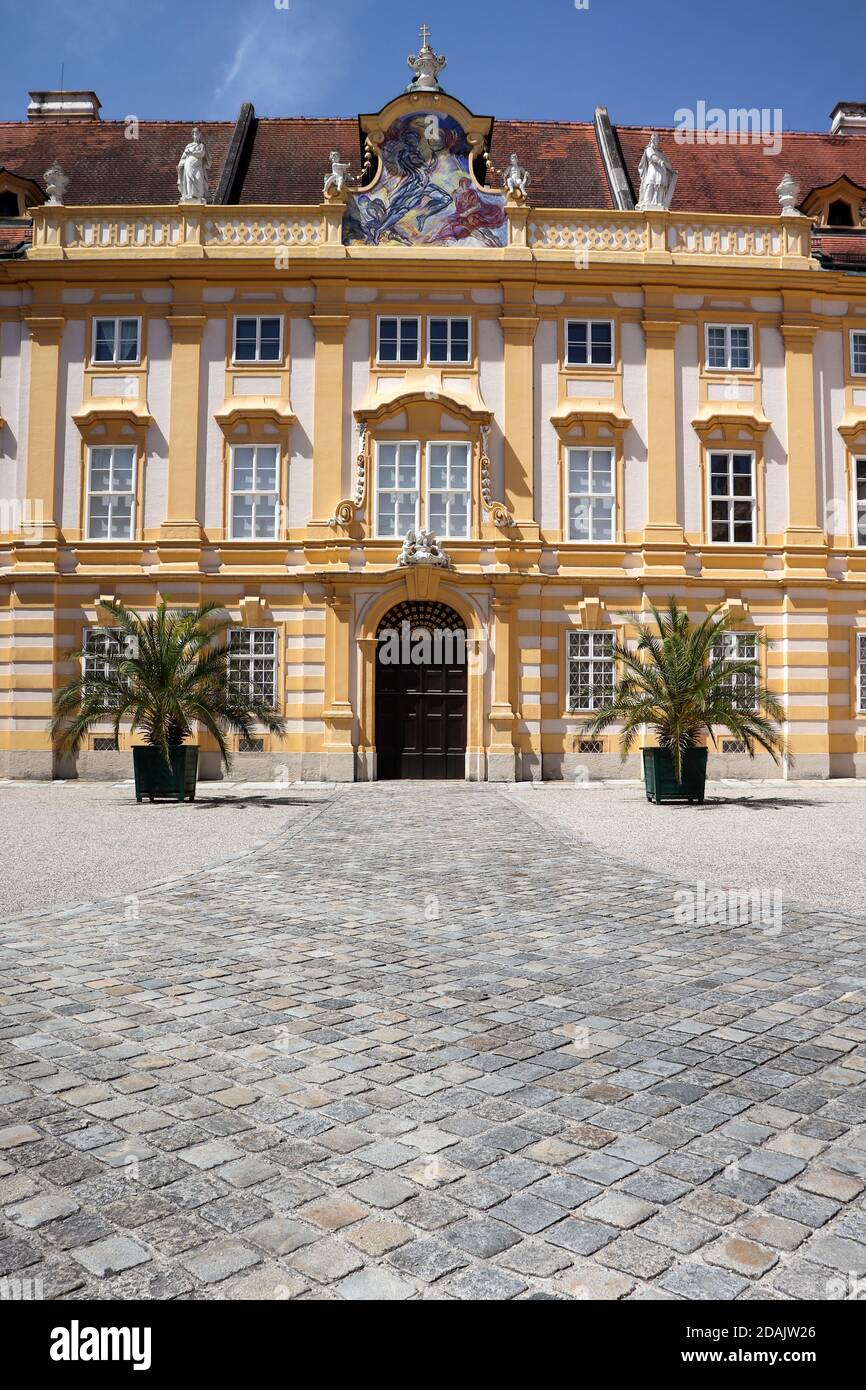 Path leading up to a door on an outside wall with rows of windows at ...