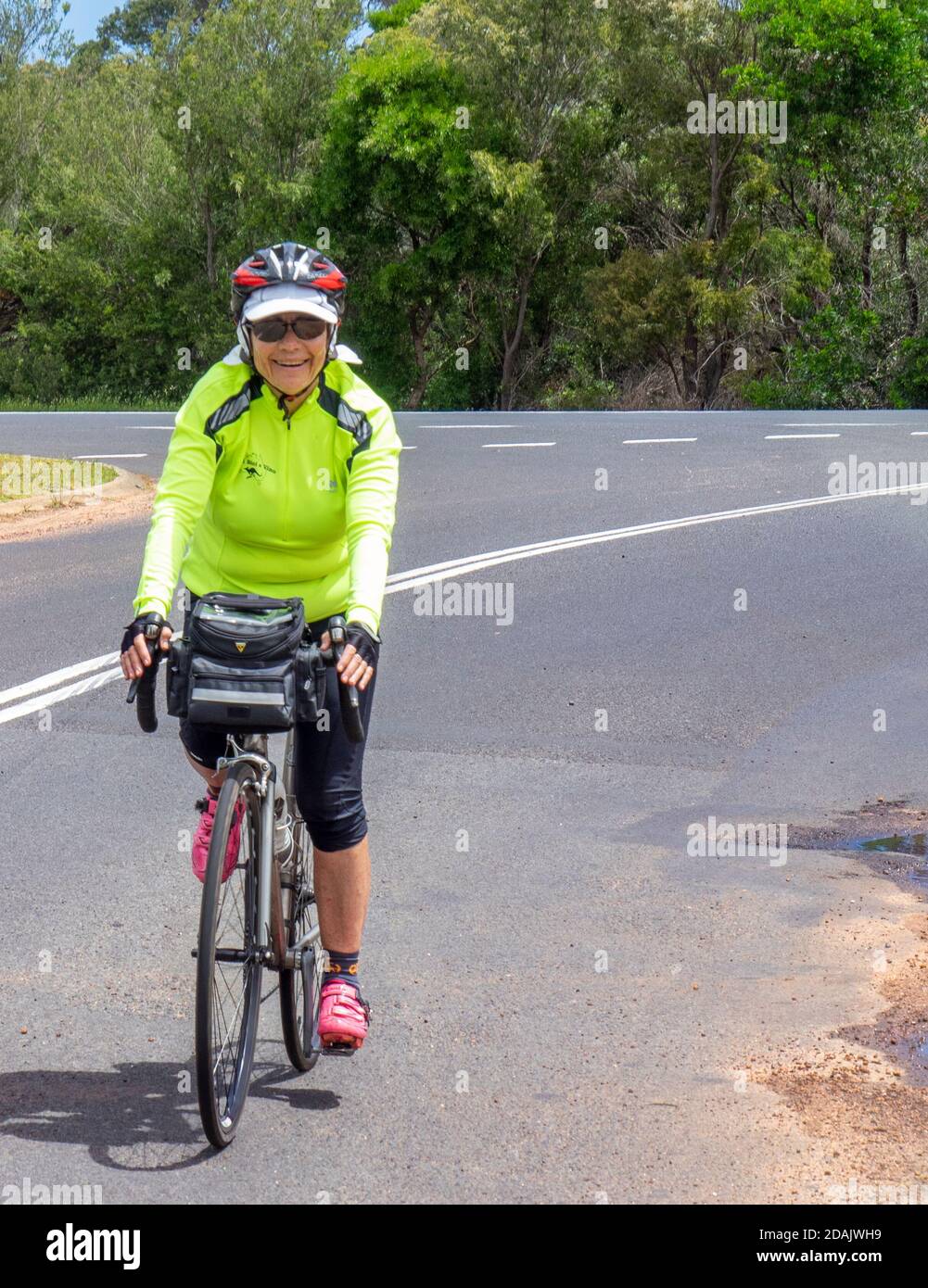 Touring cyclist travelling on vacation riding bicycle on a country road ...