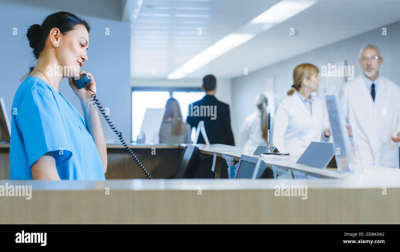 In the Hospital at the Reception Desk Nurse on Duty Talking on Phone ...
