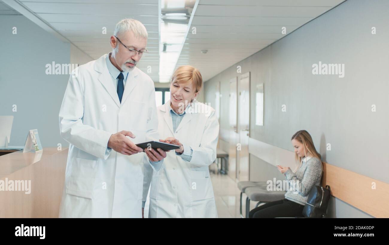 In the Hospital Two Doctors Walking Through the Hospital Hallway, They ...
