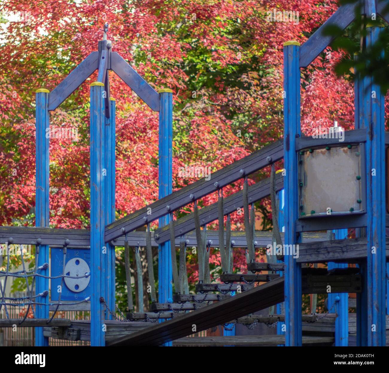 children playground with background of red leaves on the trees, autumn ...