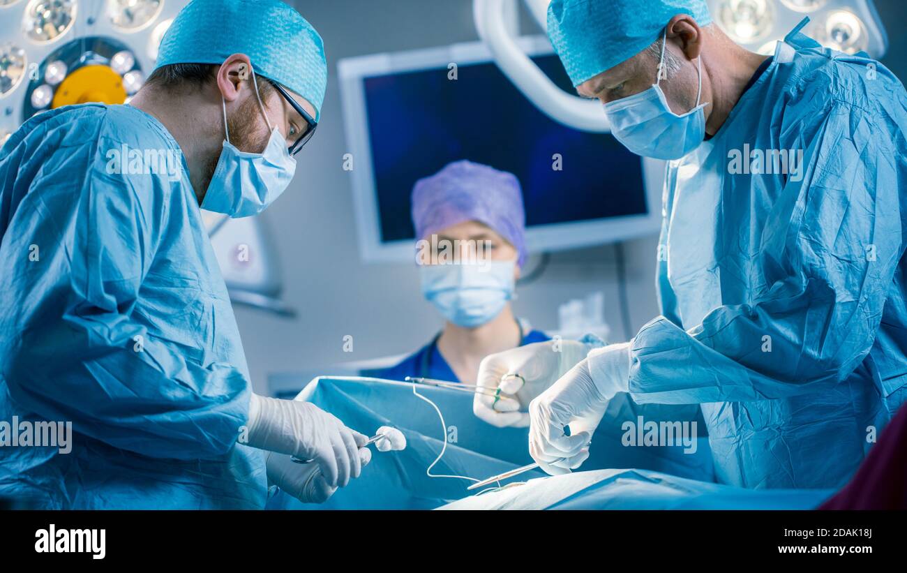 In the Hospital Operating Room Diverse Team of Professional Surgeons ...