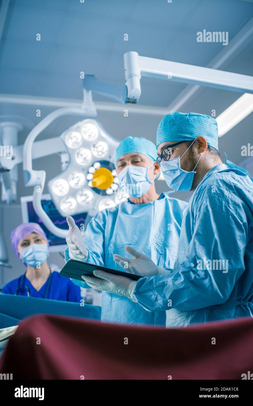 Vertical Shot of a Professional Surgeon and Assistant Talk and Use ...