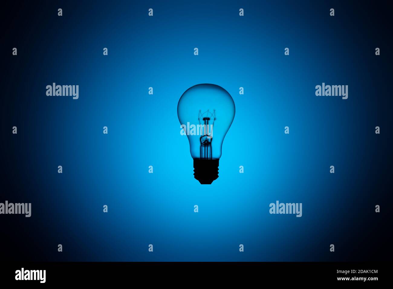 The incandescent light bulb is in the center of the photo against a ...