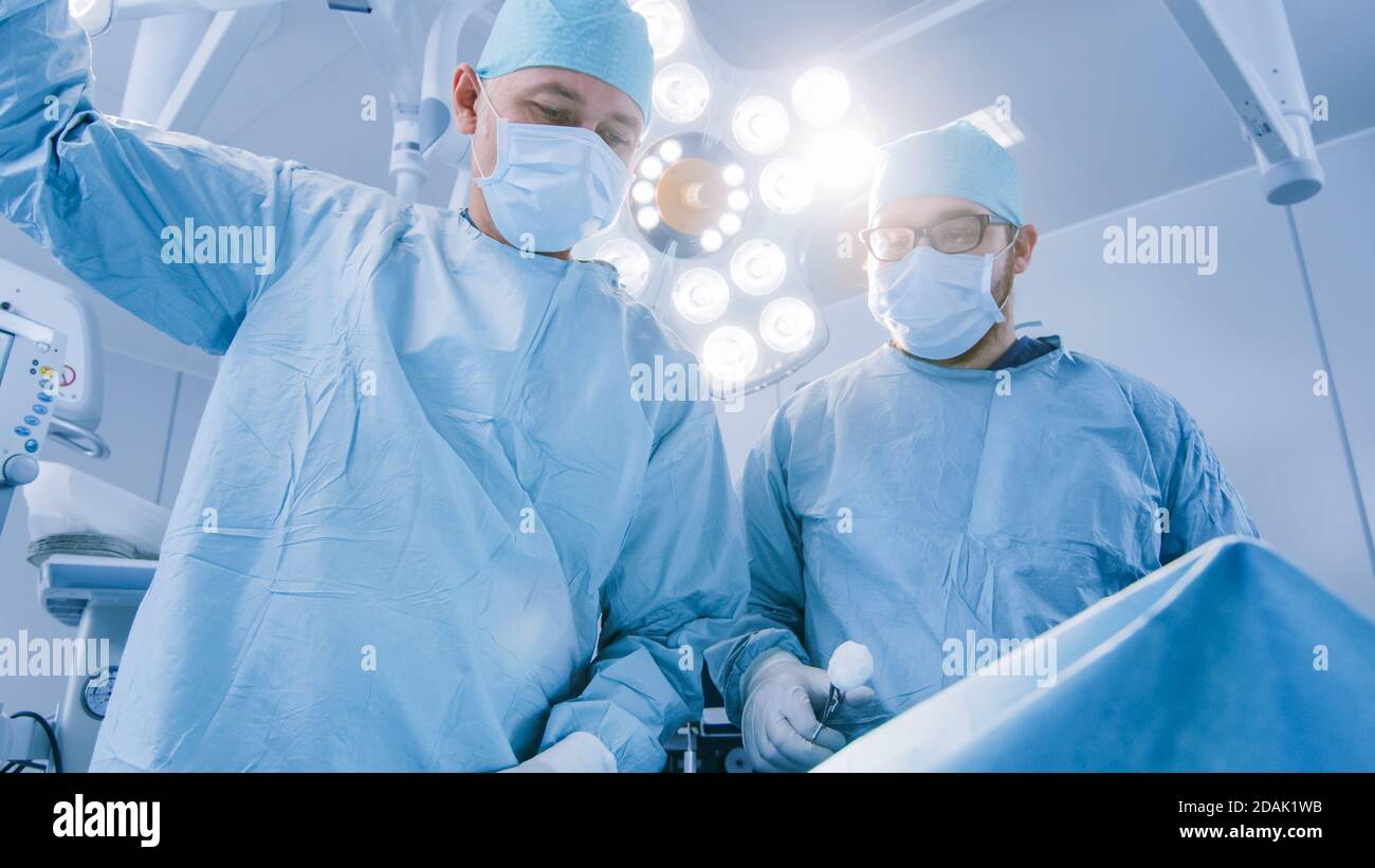 Low Angle Shot In Operating Room of Two Surgeons During the Surgery ...