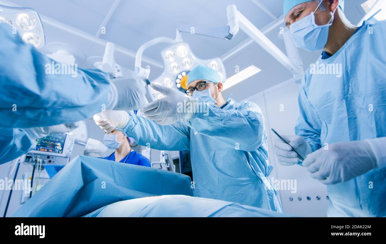 Low Angle Shot of a Diverse Team of Professional Surgeons Performing ...